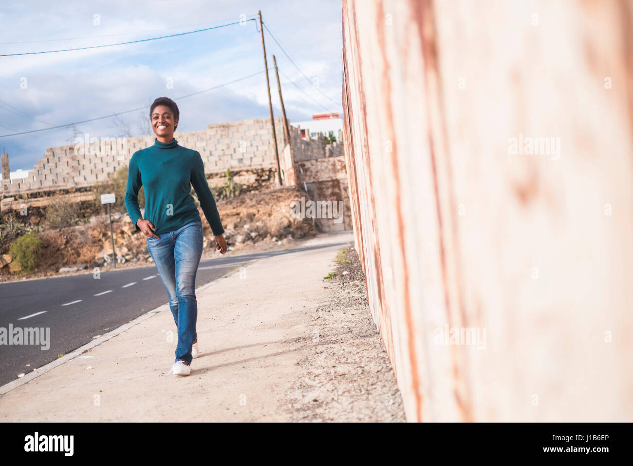 African American woman walking on urban sidewalk Stock Photo - Alamy