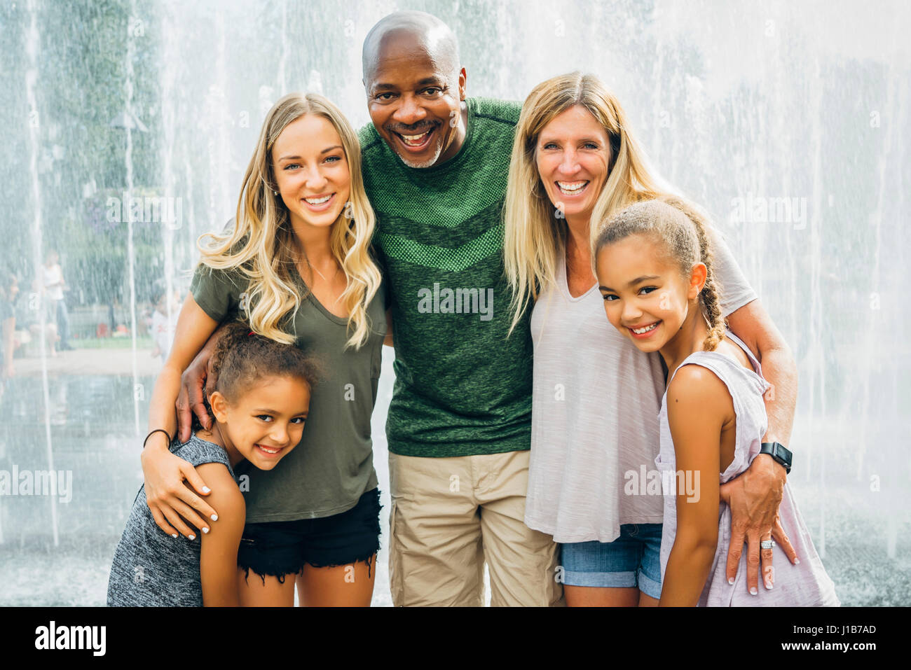 Multi-ethnic family posing near fountain Stock Photo - Alamy