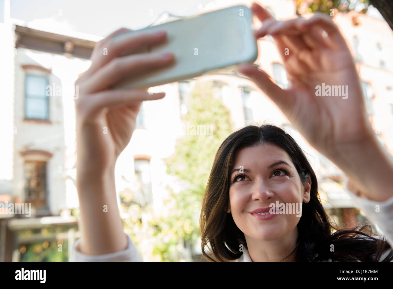 Smiling Caucasian woman posing for cell phone selfie Stock Photo - Alamy