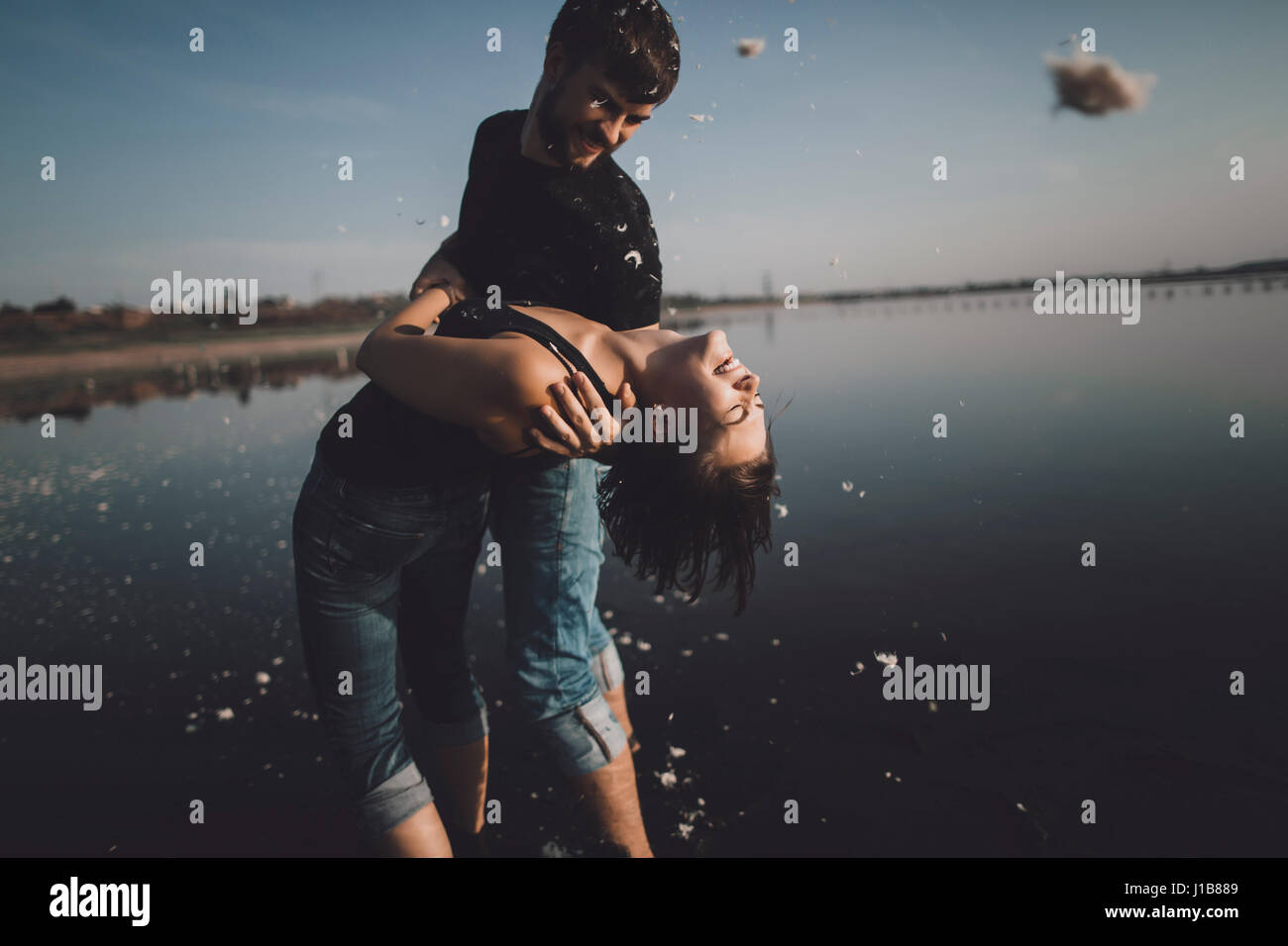 Caucasian man dipping woman at lake Stock Photo - Alamy