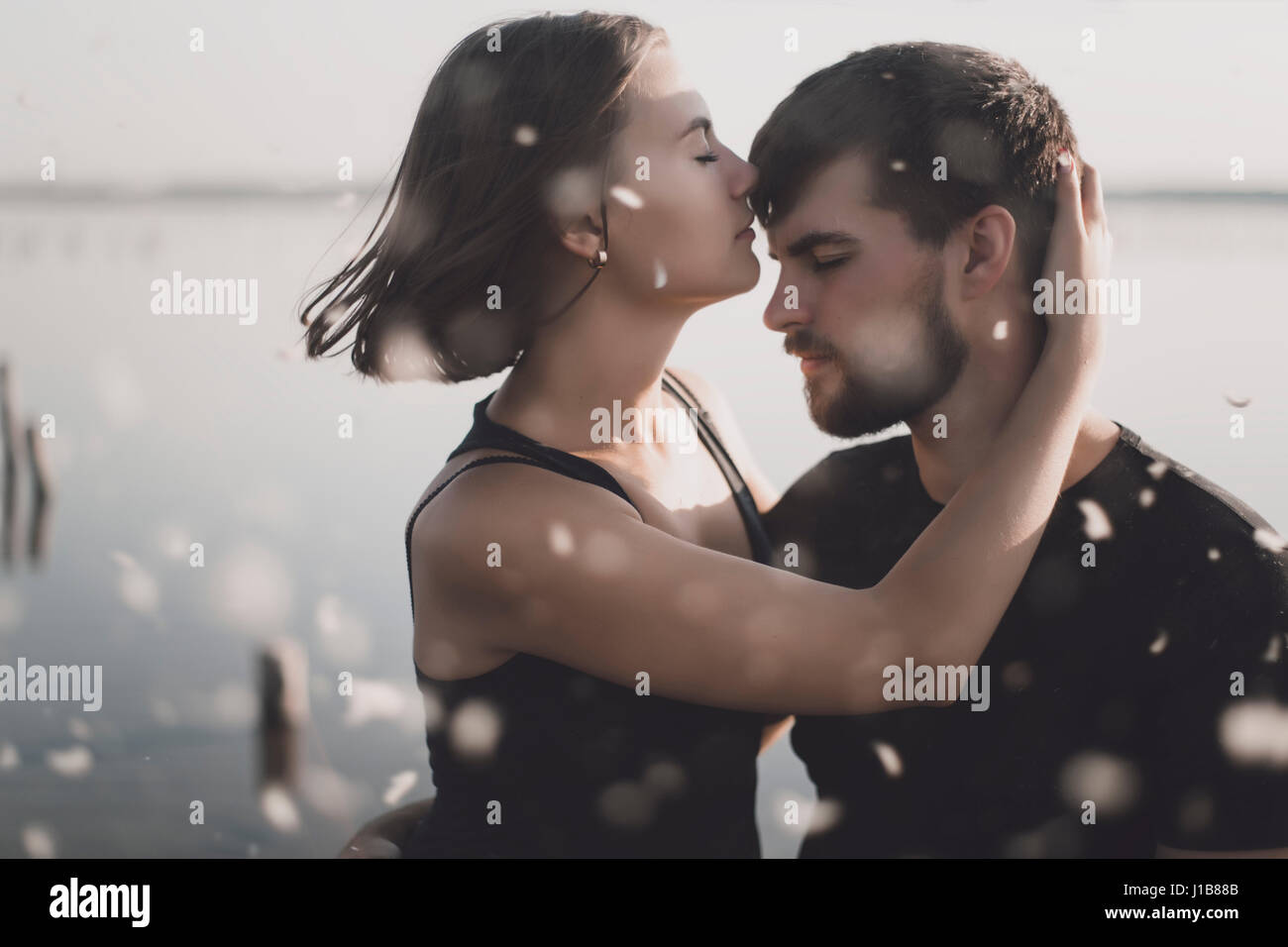 Water splashing on Caucasian couple hugging at lake Stock Photo - Alamy