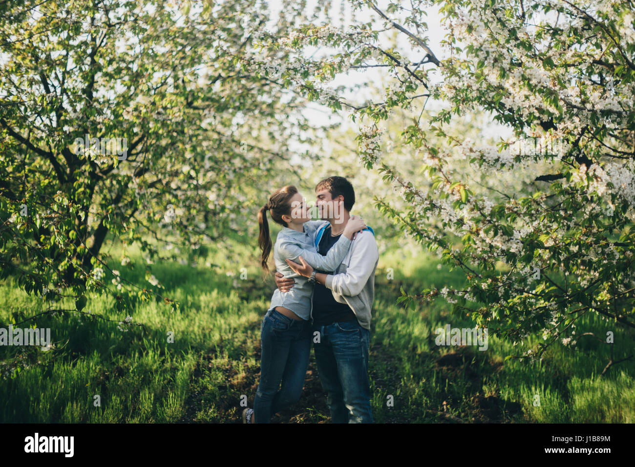Caucasian couple kissing under flowering trees Stock Photo - Alamy