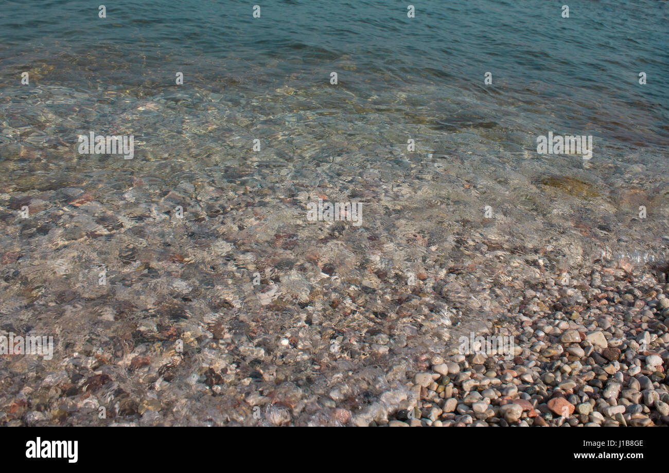 Pebbles in crystal clear lake water close up Stock Photo - Alamy