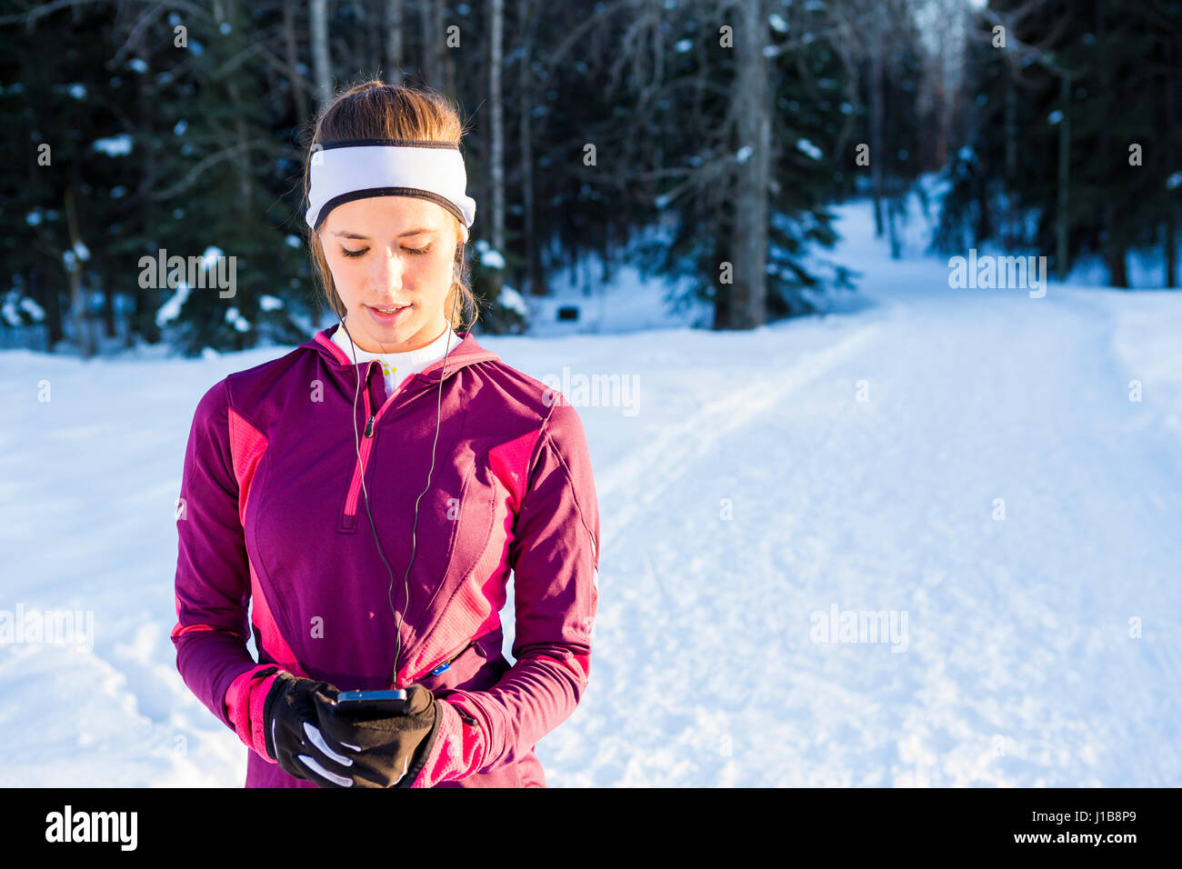 Caucasian woman listening to cell phone with earbuds Stock Photo - Alamy