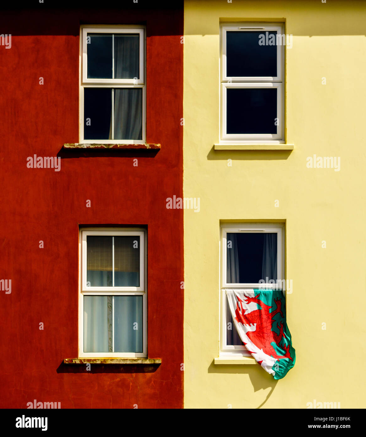 The Welsh flag hanging from a window in Aberystwyth, Wales Stock Photo ...