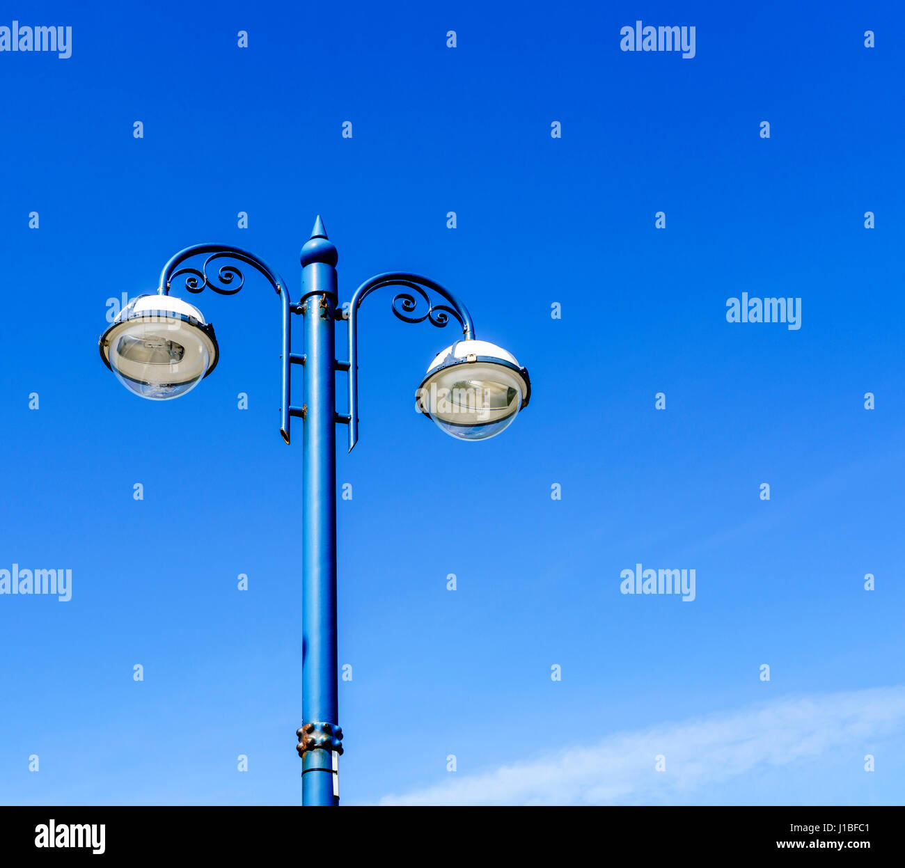 An attractive blue street lamp set against a clear blue sky in ...
