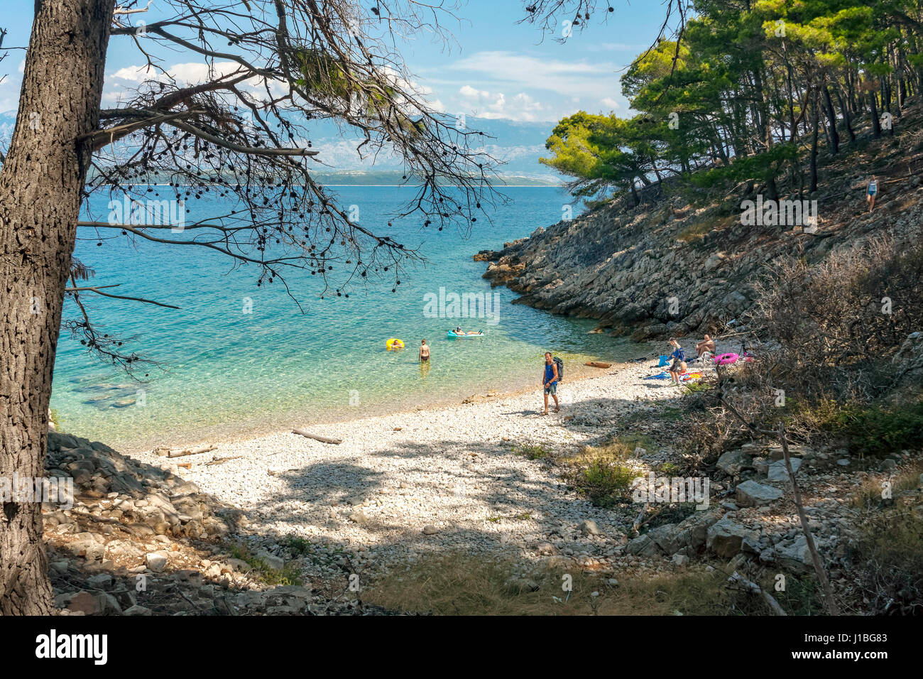 Tourists on a small pebble beach near Lun, Pag island, Croatia Stock ...