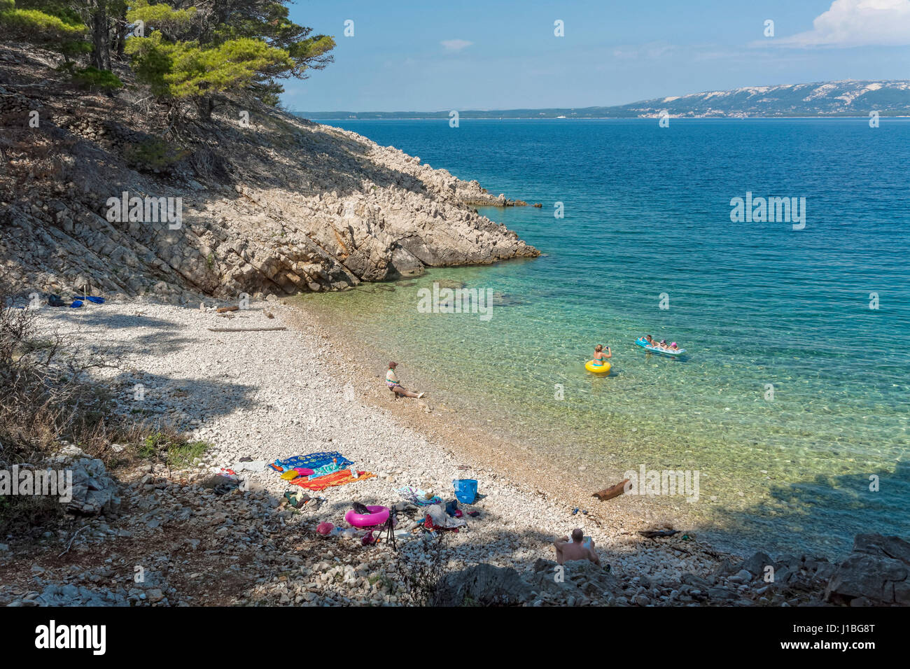 Tourists on a small pebble beach near Lun, Pag island, Croatia Stock ...