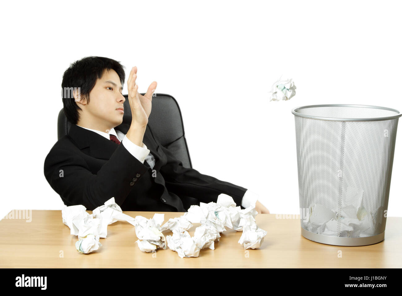 A businessman throwing trash paper into waste basket Stock Photo - Alamy