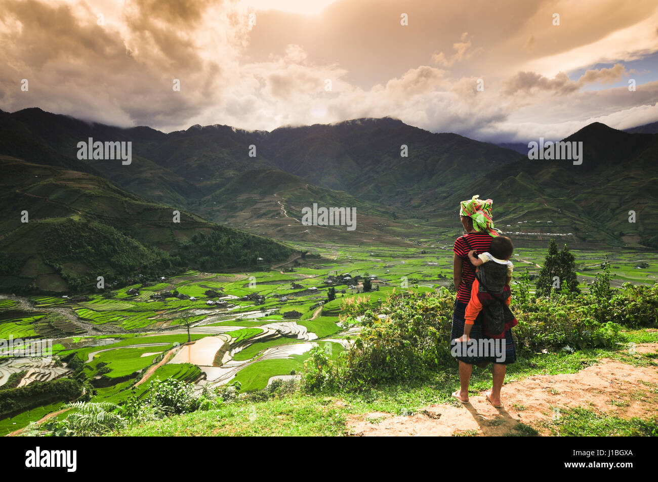 Hmong ethnic minority woman with her sun in terraced rice field in Mu ...