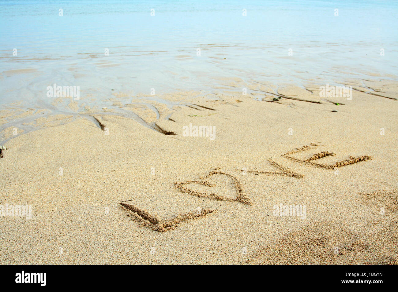 Drawing of letters of LOVE on a sandy beach Stock Photo - Alamy