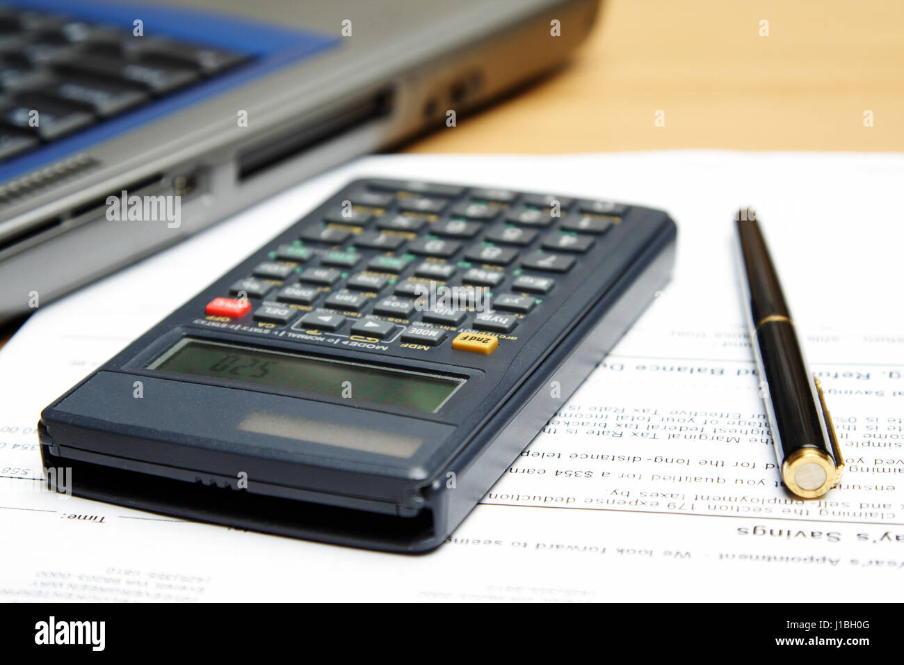 A laptop, calculator and accounting paperwork showing typical business ...