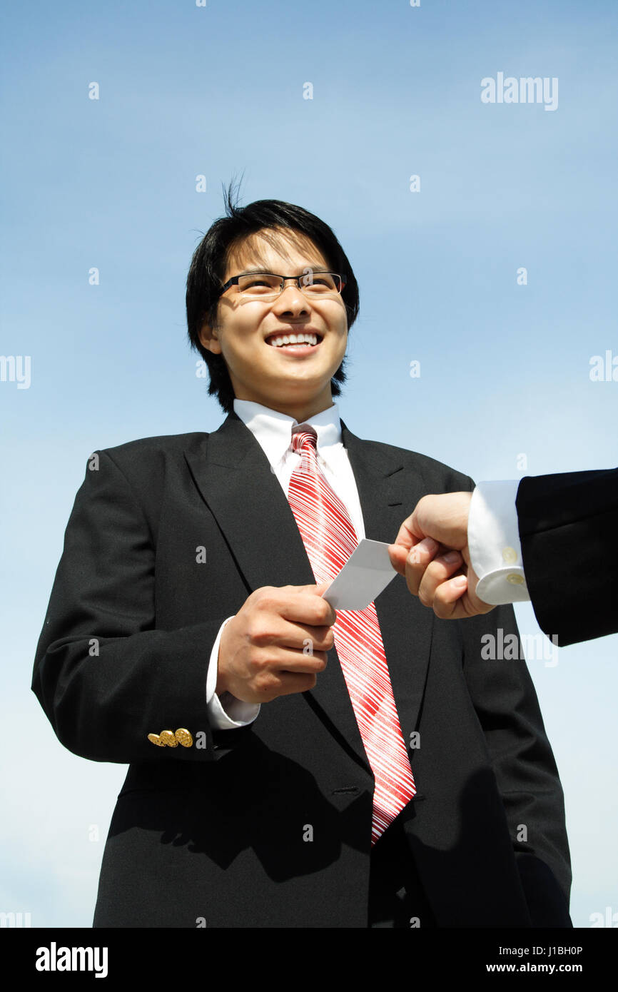 A businessman receiving a business card from his business partner Stock ...