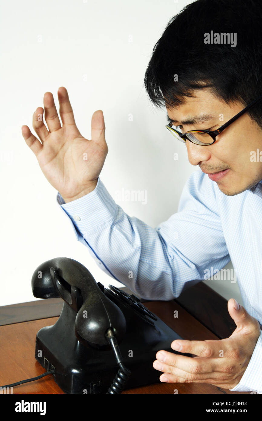 An impatient and stressed out businessman waiting for a phone call ...