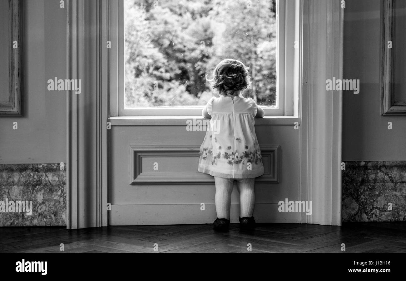 Child looking out of window Stock Photo - Alamy