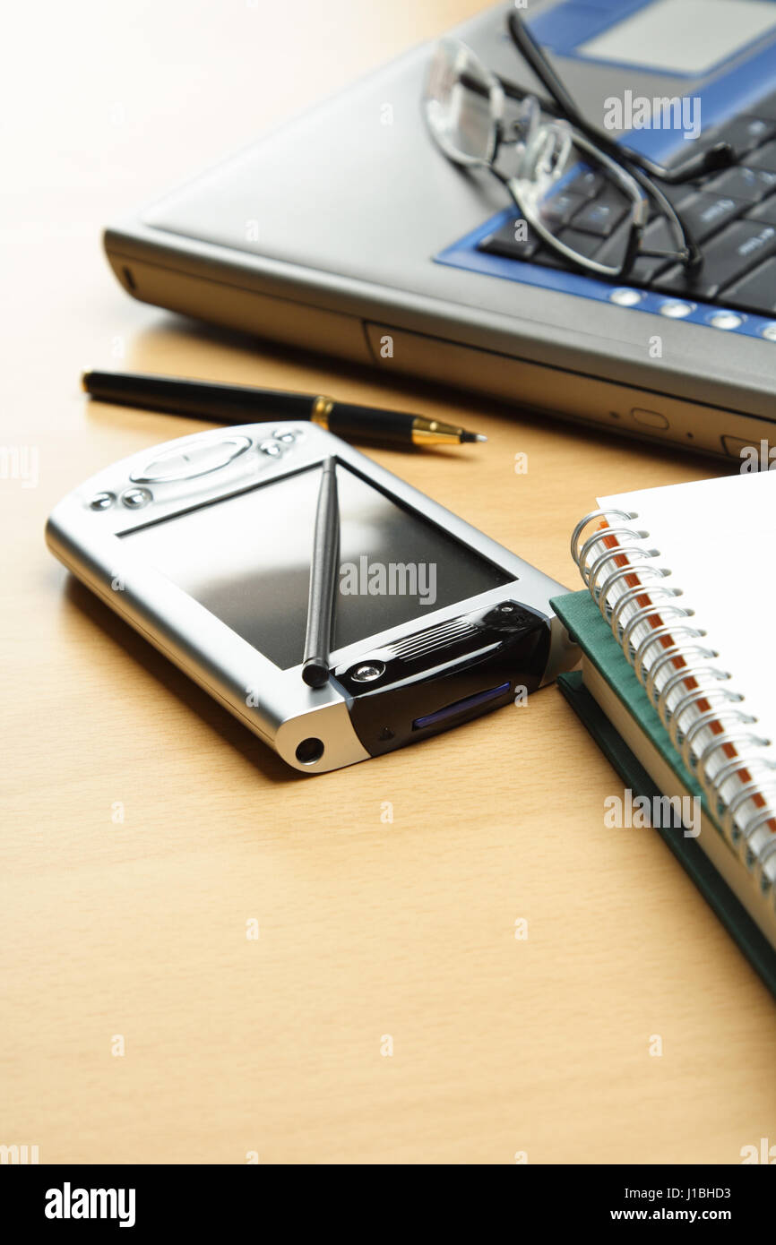 A laptop, PDA and a notebook in business office environment setting Stock Photo - Alamy