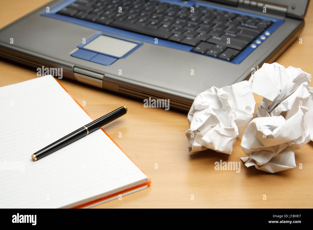 A laptop and a notebook with crumpled paper, can be used as business ...
