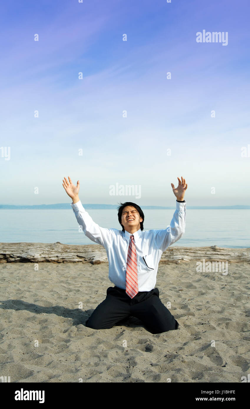 A stressed businessman crying and kneeling on the beach Stock Photo - Alamy