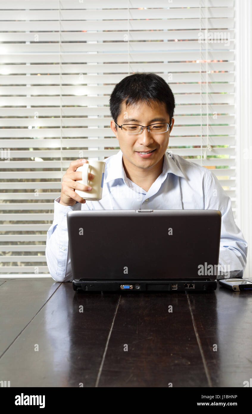 An asian businessman working on his laptop Stock Photo - Alamy