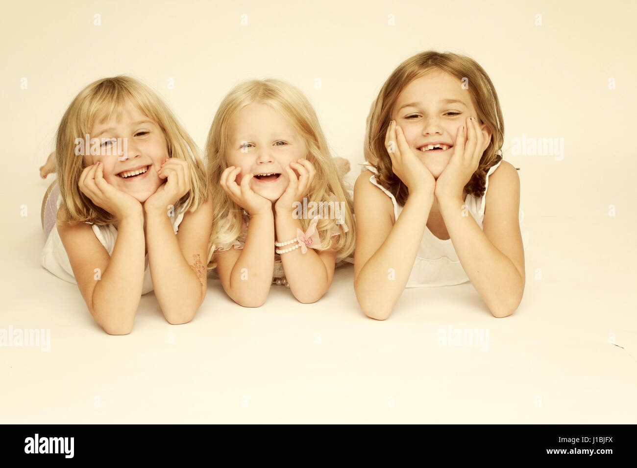 happy blonde children, three girls smiling, sibling love, joy concept ...