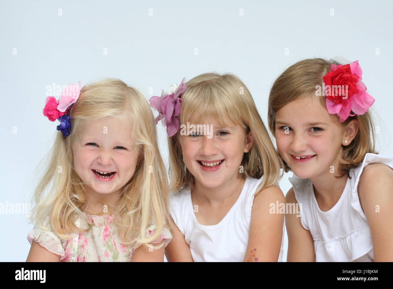 Three blonde sisters portrait lying tummies smiling laughing, sibling ...