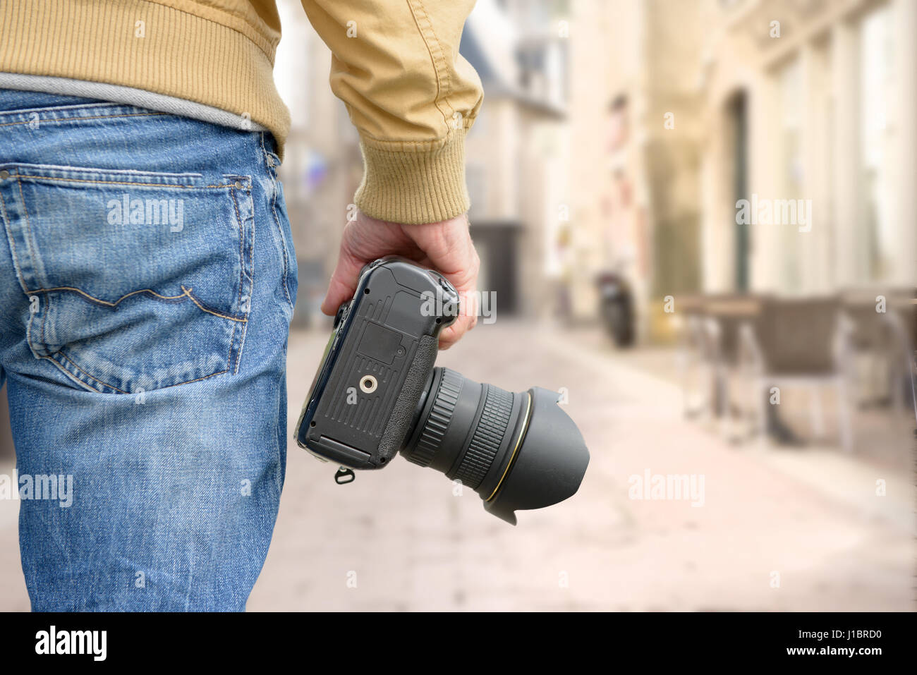 man photographer holding his photo camera, outdoor Stock Photo - Alamy