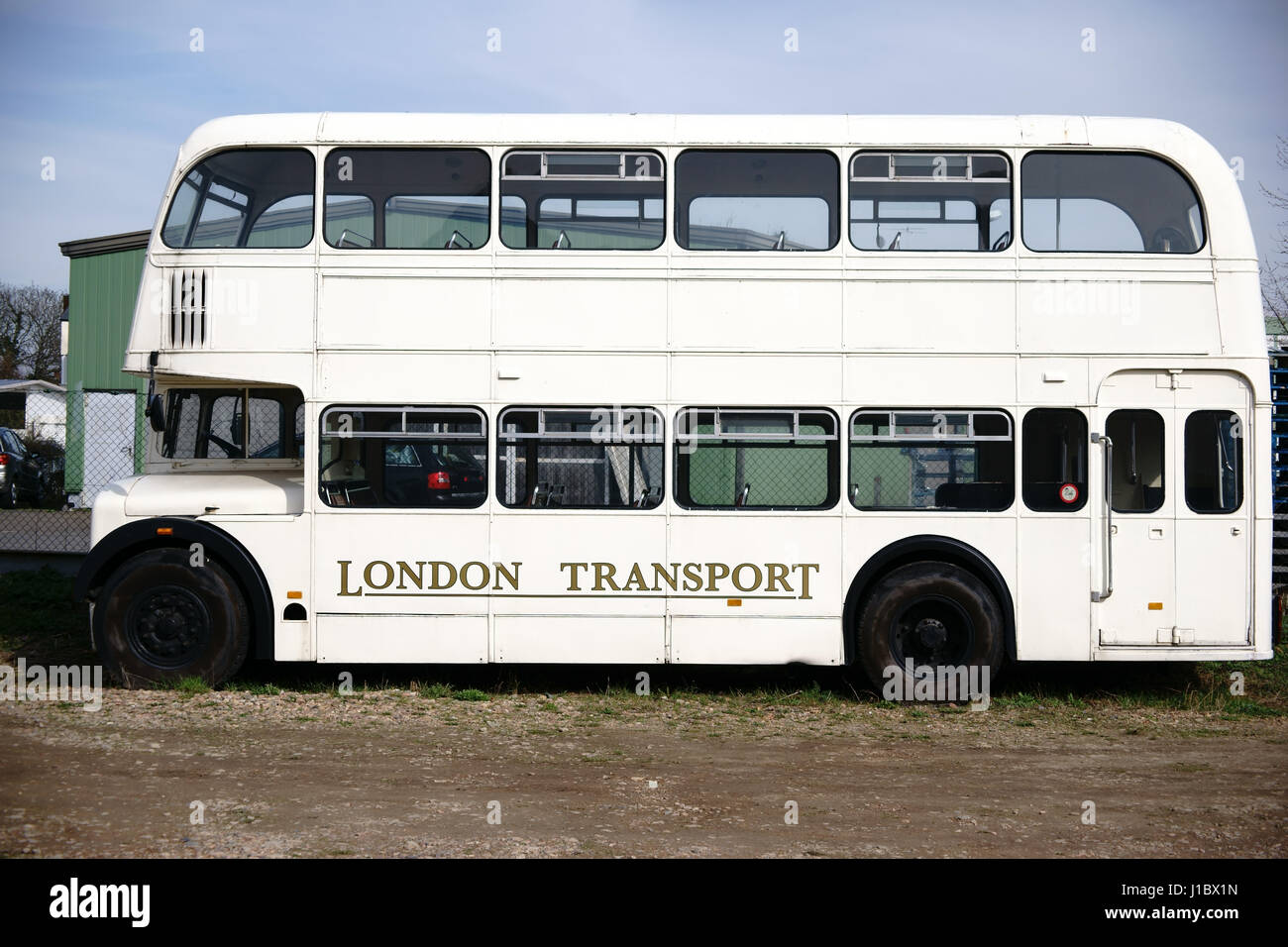 The side view of an old discarded double decker bus on a scrap yard ...