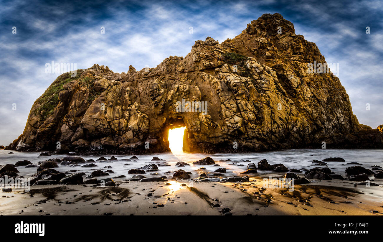A gate in a shore large rock Stock Photo - Alamy