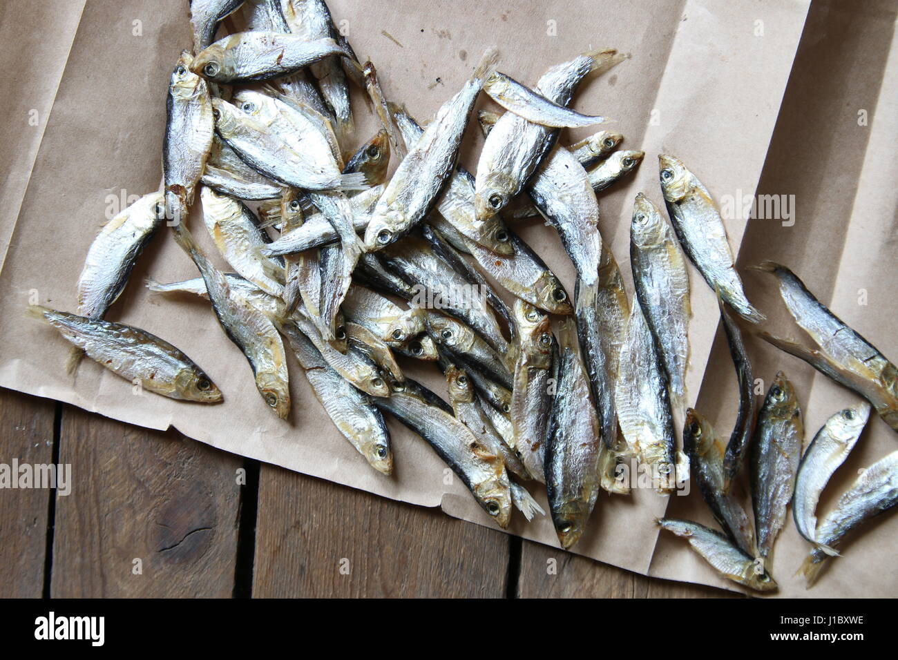 Sun dried fish on the brown paper. Soft focus Stock Photo - Alamy