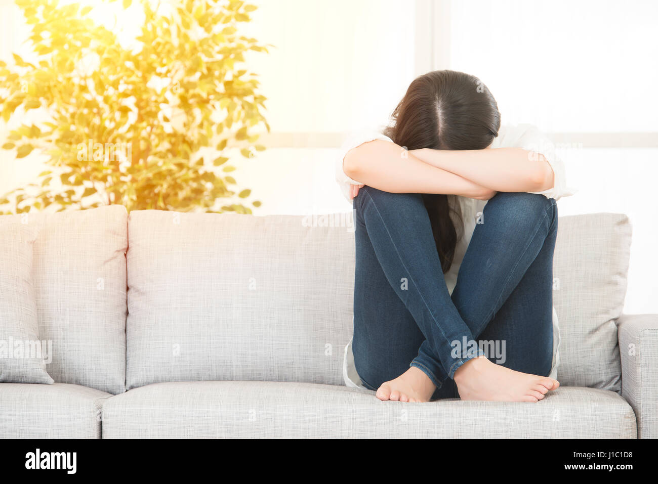 Sad depressed woman at home she is sitting on the couch. loneliness and ...