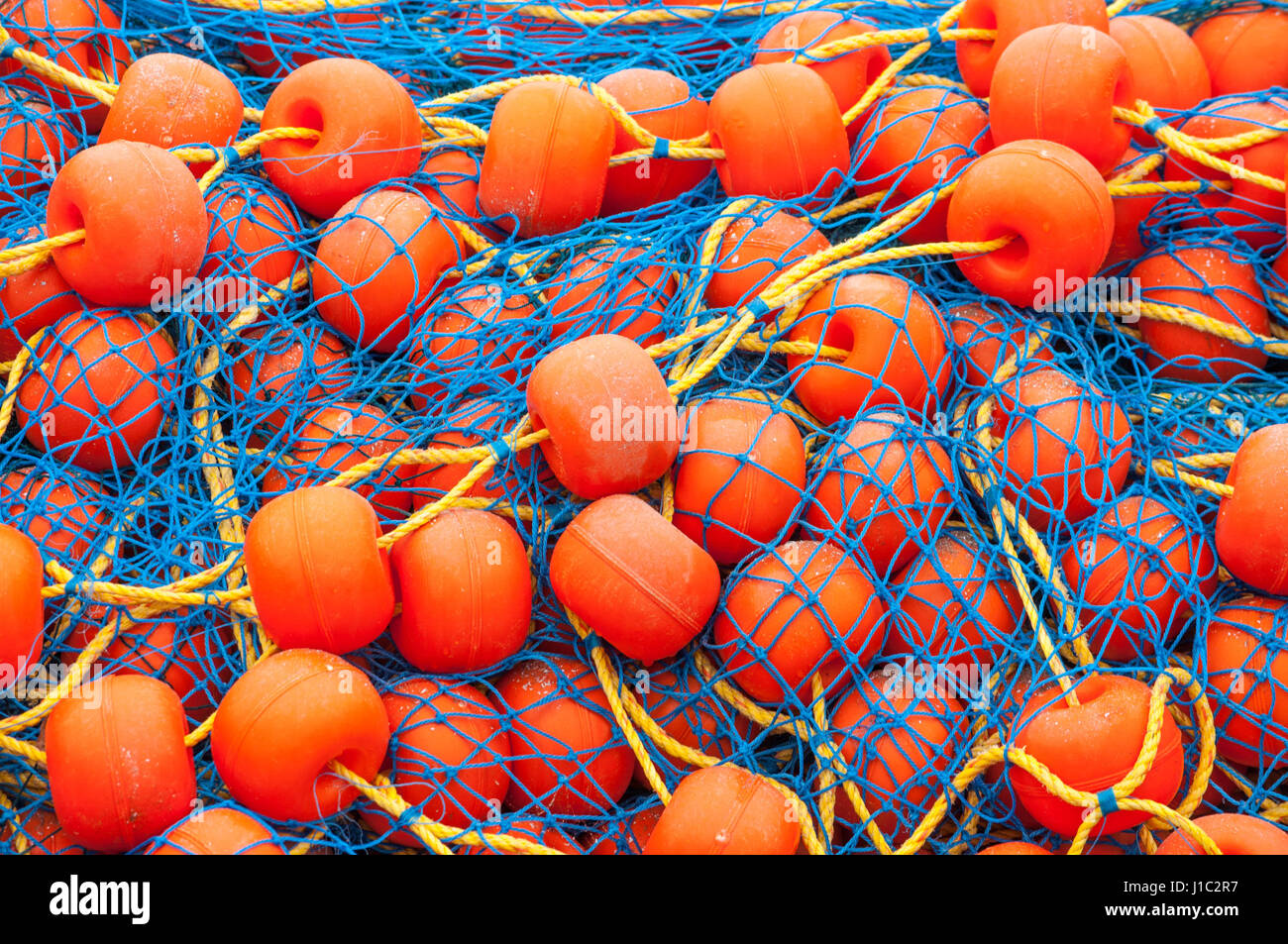 Bright blue fishing net with orange floats closeup Stock Photo - Alamy