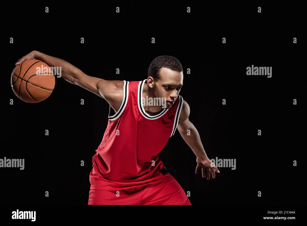 Handsome african american man playing basketball on black Stock Photo ...