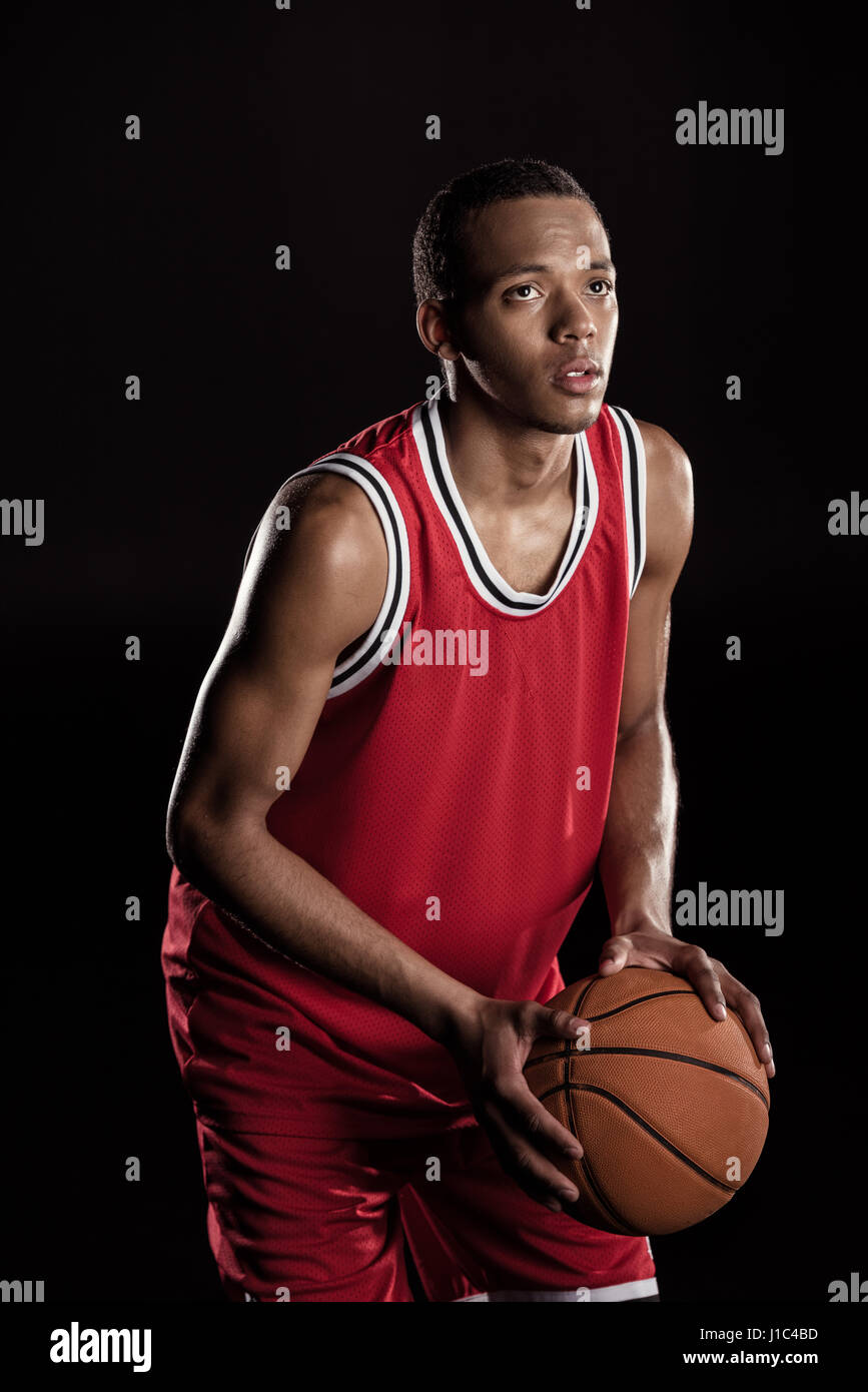 african sporty man in sports uniform playing basketball on black Stock ...