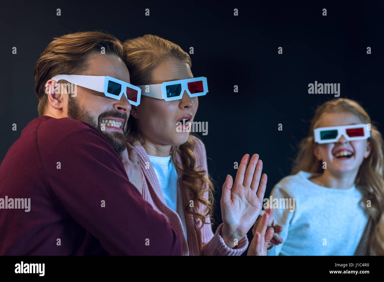 Scared family wearing 3d glasses watching movie together Stock Photo ...