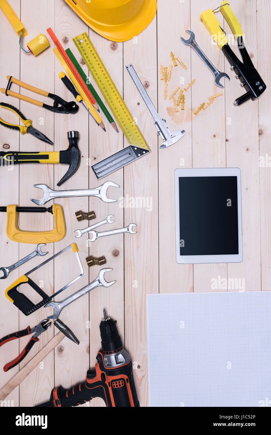 Top view of different tools with blueprint and digital tablet on wooden ...