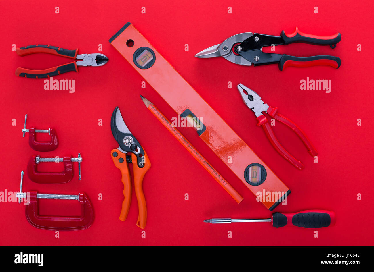 top view of various work tools and pencil on red Stock Photo - Alamy