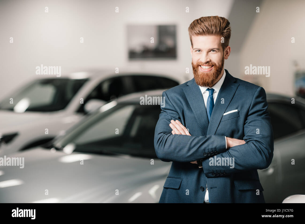 salesman in suit with crossed arms posing and looking at camera in ...