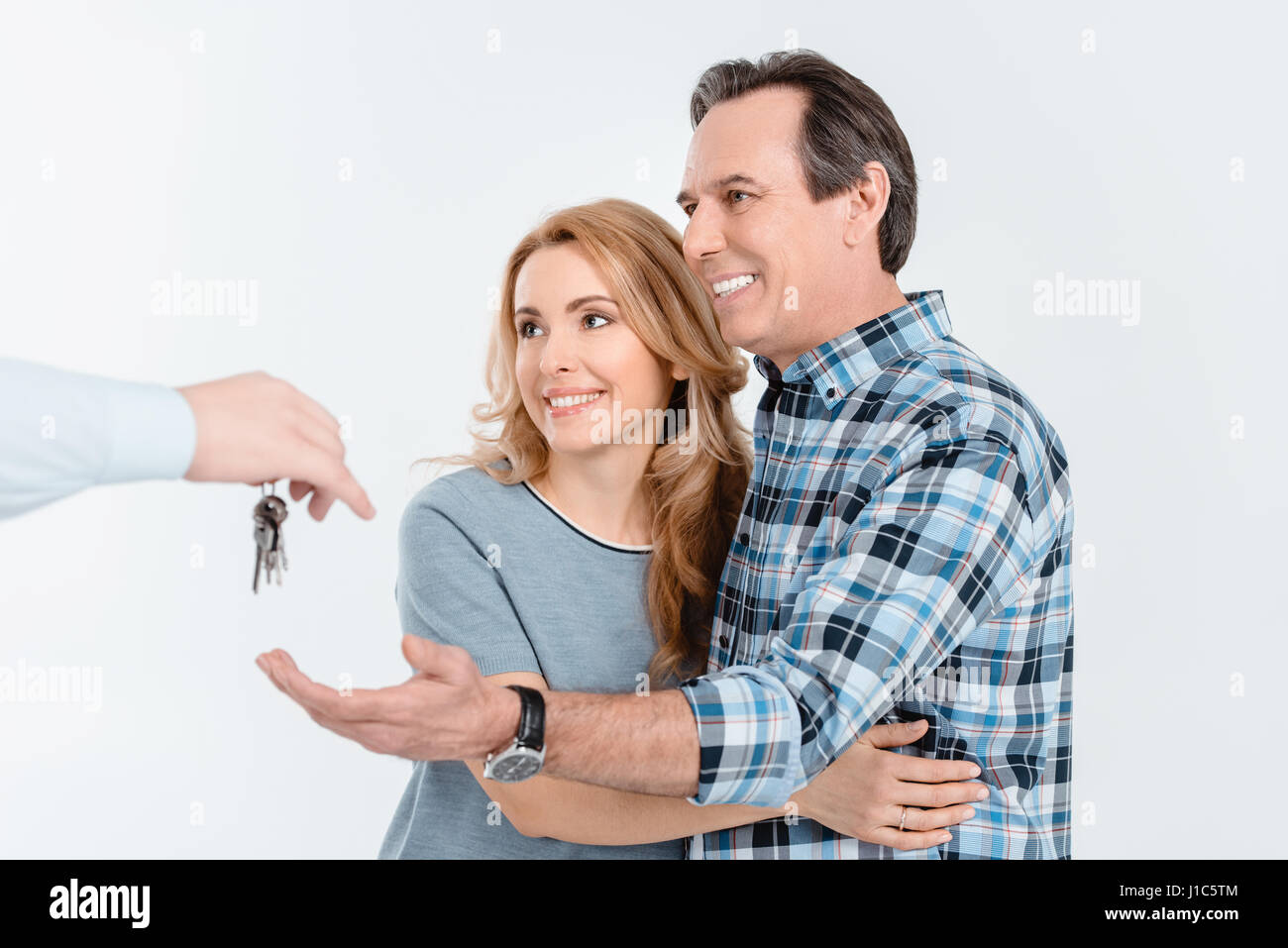portrait of happy couple receiving keys from new house on white Stock ...