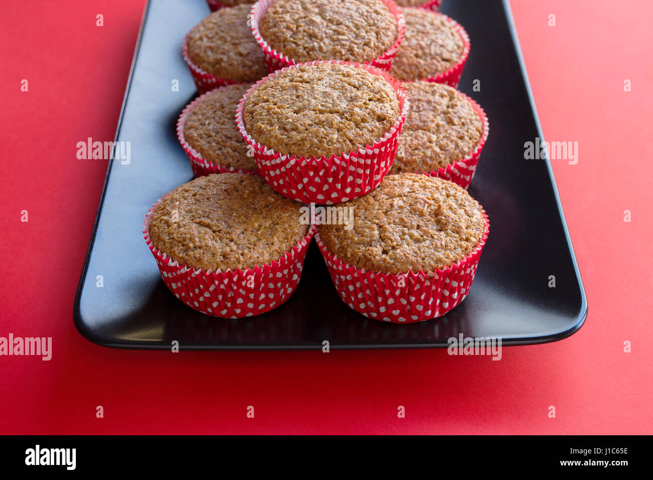 Bran muffins in bright red and white paper holders on a black ...