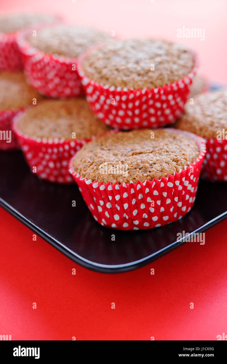 Bran muffins in bright red and white paper holders on a black ...