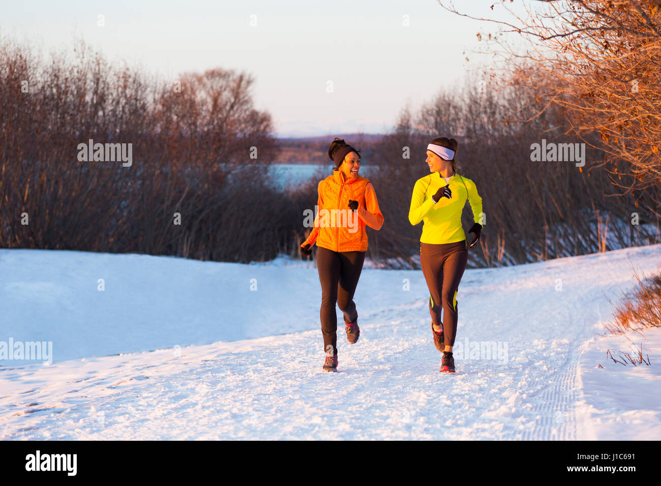 Women running on snow in winter Stock Photo - Alamy