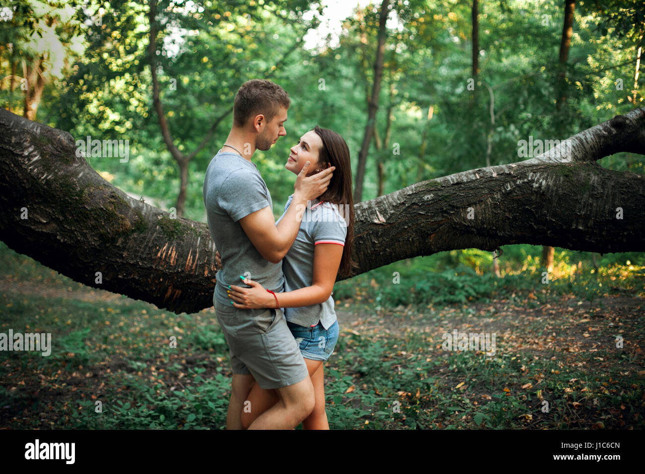 Caucasian couple hugging near tree branch Stock Photo - Alamy