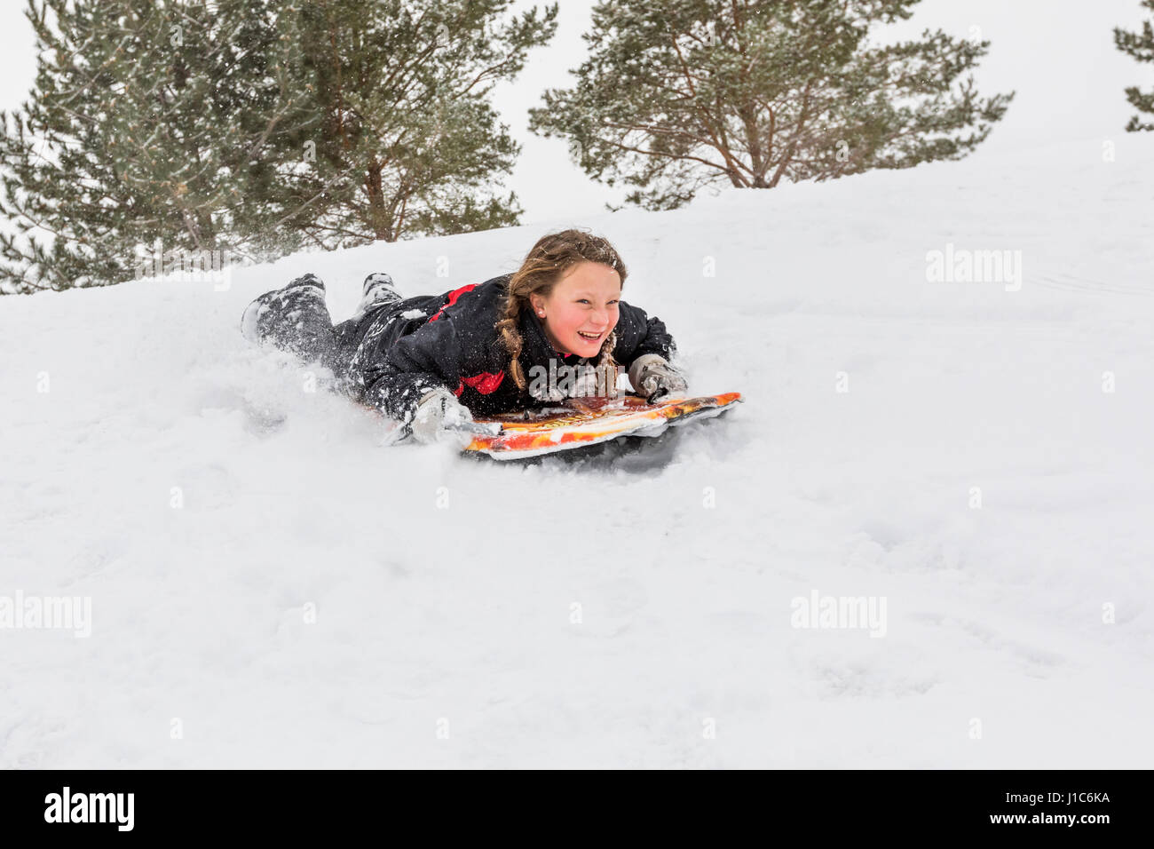 Happy girl on snowboard sliding hi-res stock photography and images - Alamy