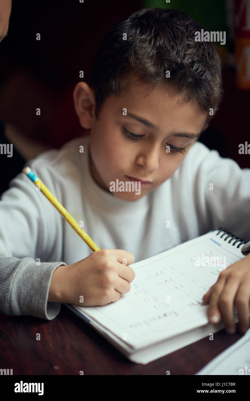 Hispanic boy practicing writing alphabet Stock Photo - Alamy