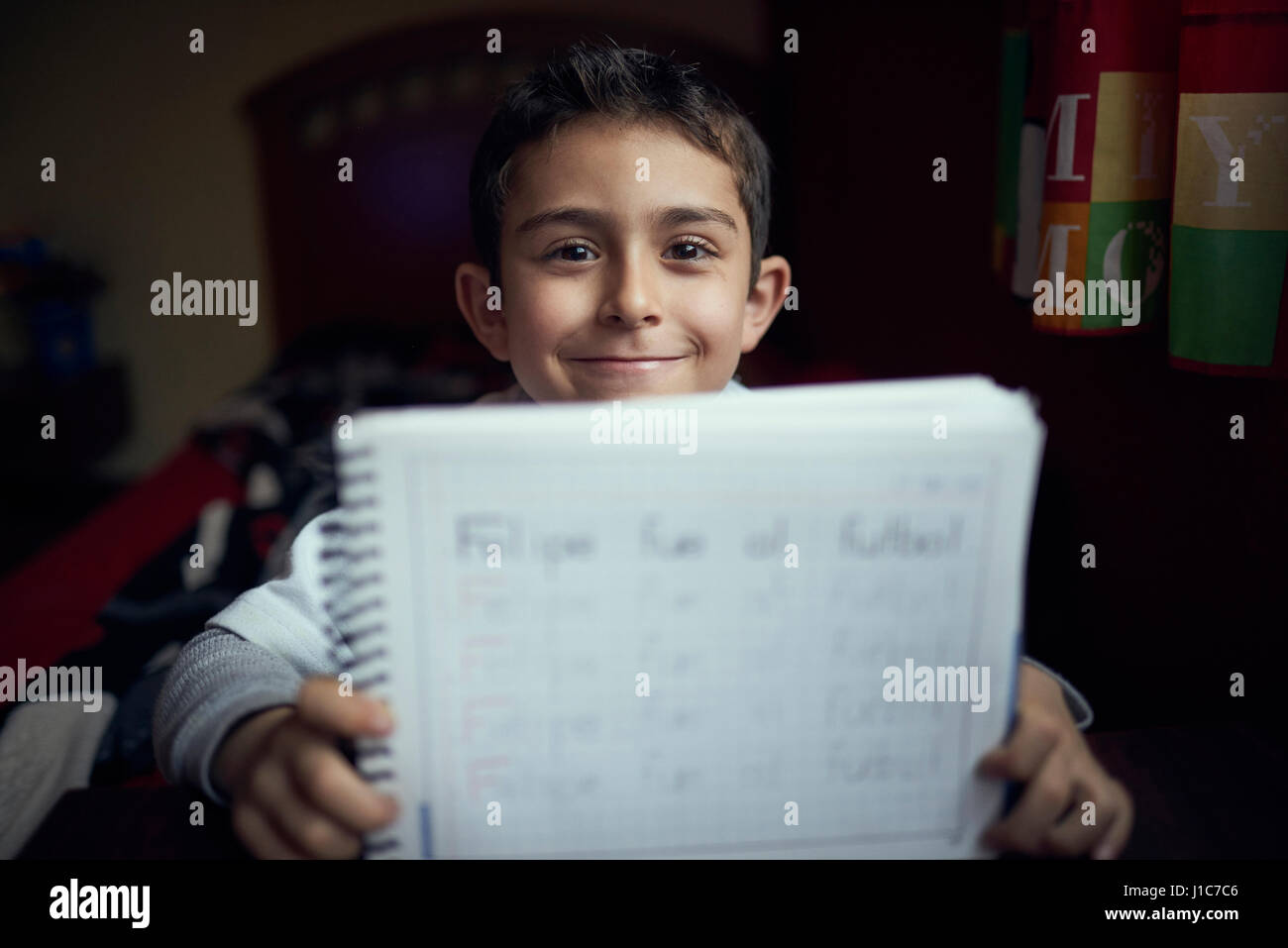 Proud Hispanic boy practicing writing alphabet Stock Photo - Alamy