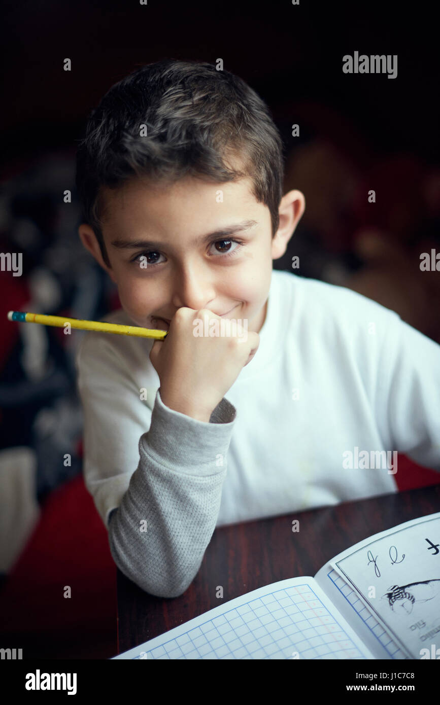 Smiling Hispanic boy practicing writing alphabet Stock Photo - Alamy