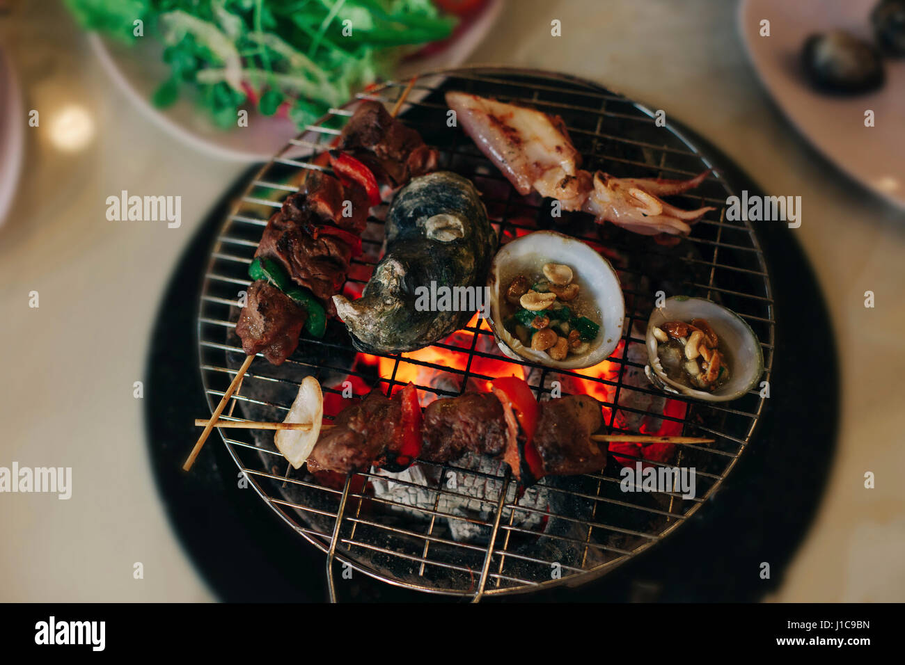 Seafood cooking on grille Stock Photo - Alamy