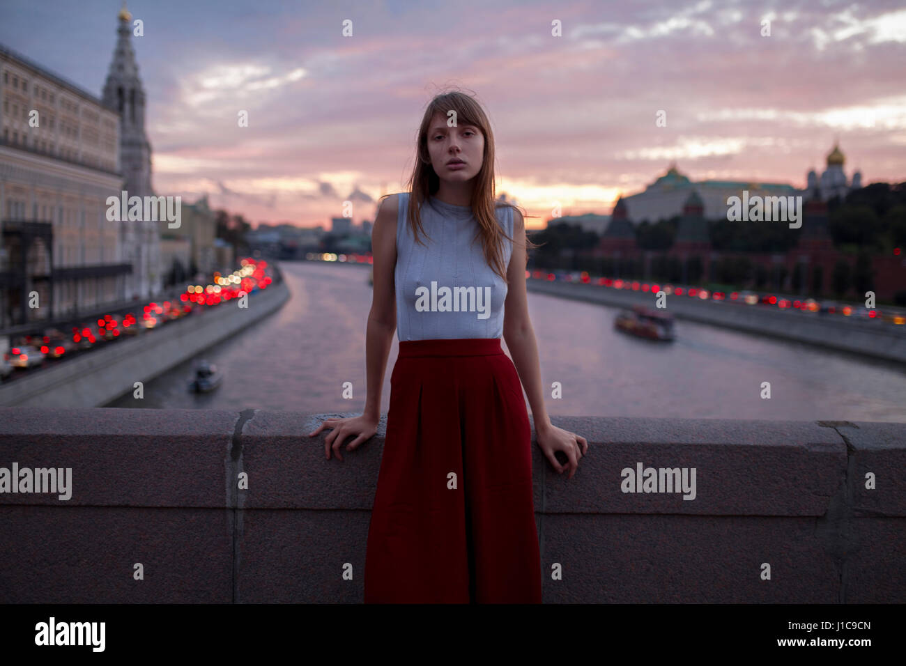Caucasian woman leaning on bridge over urban canal Stock Photo - Alamy