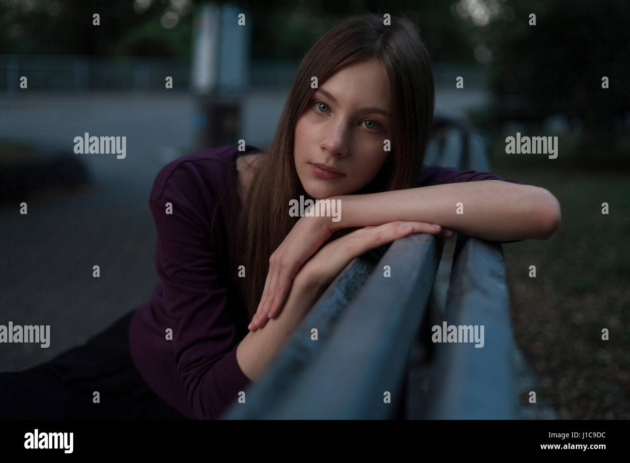 Serious Caucasian woman leaning on bench Stock Photo - Alamy