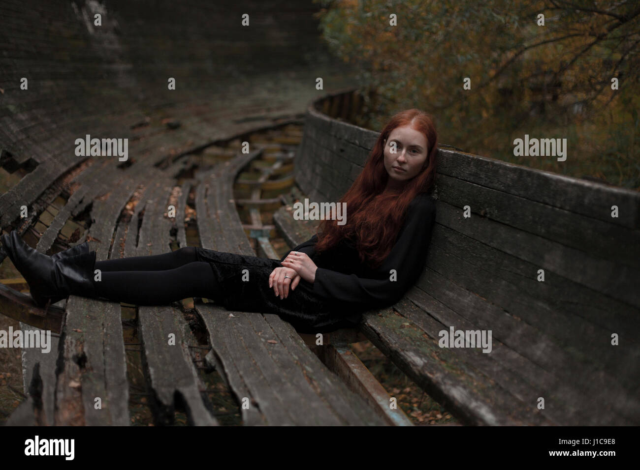 Caucasian woman sitting on rotting wooden bench Stock Photo - Alamy